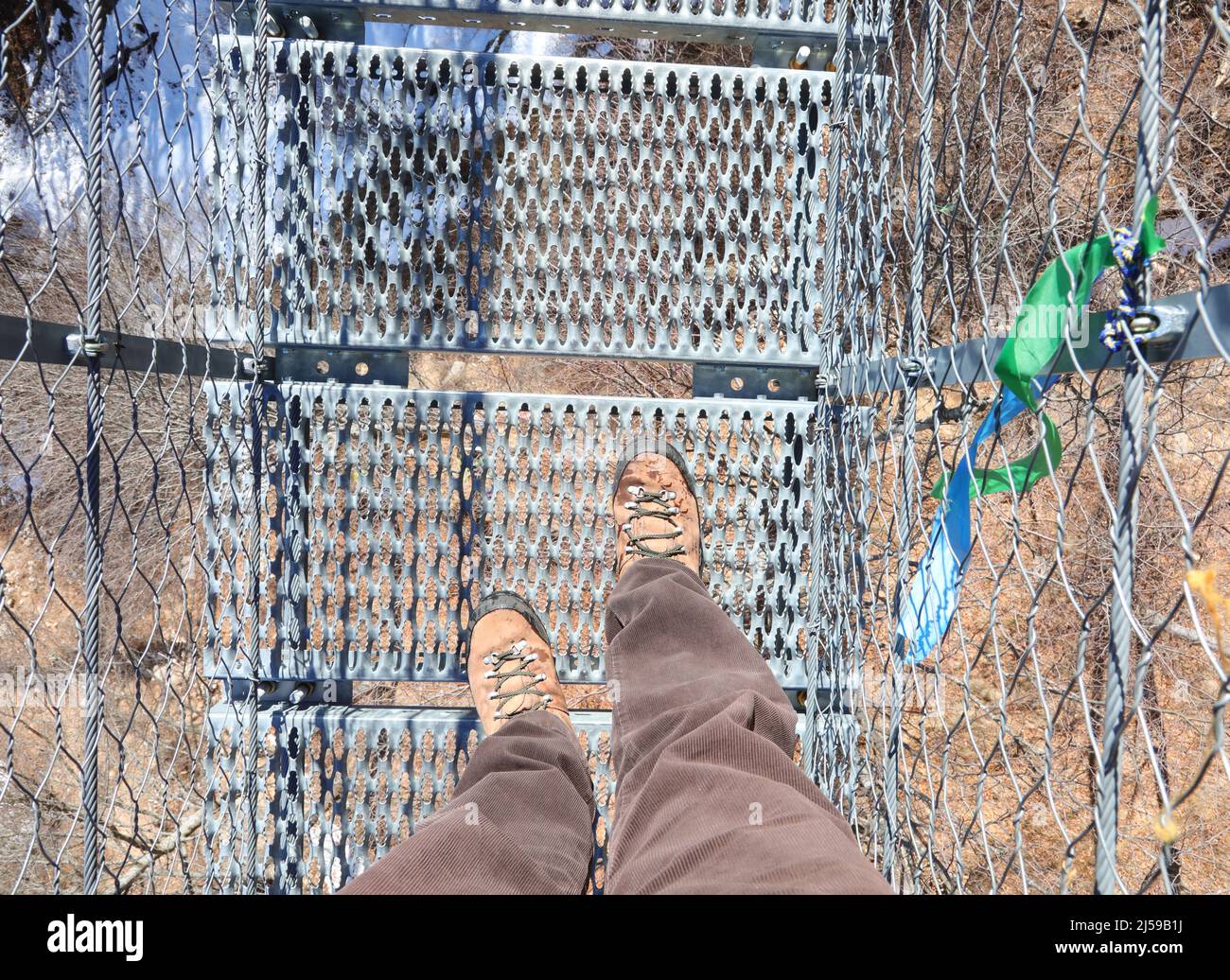 two boots of the intrepid explorer who walks on the suspension bridge ...