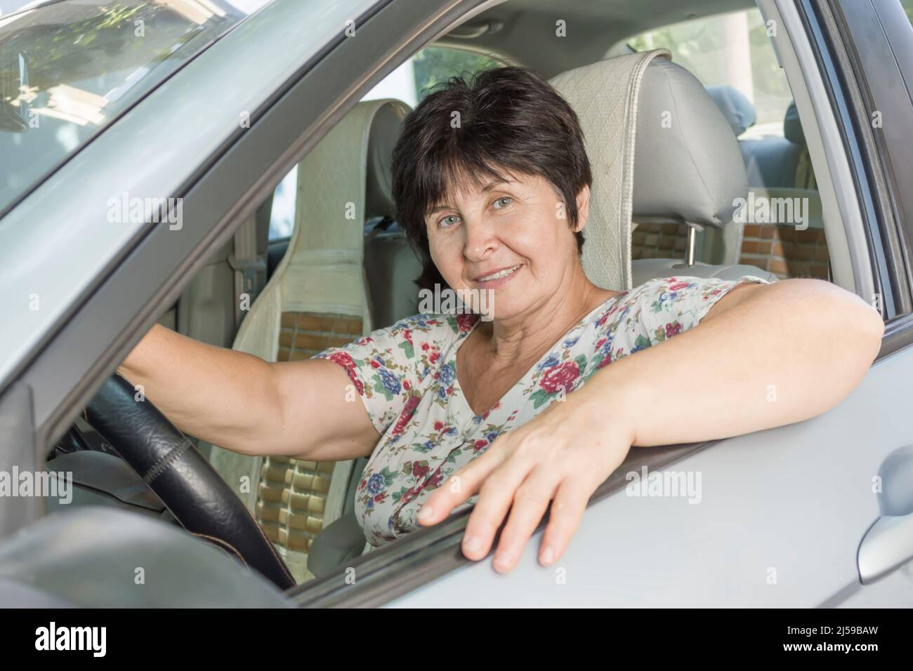 Middle-aged beautiful woman driver driving a car Stock Photo - Alamy
