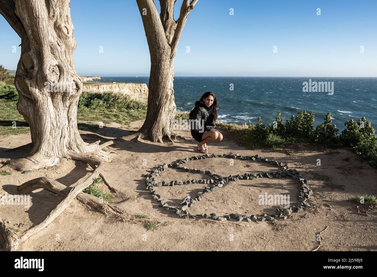 Young Woman Beside Peace Symbol Overlooking the Ocean | Lifestyle Local ...