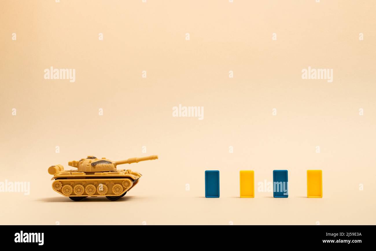 Tank and toy dominos on sand color background. Minimal Ukraina concept ...