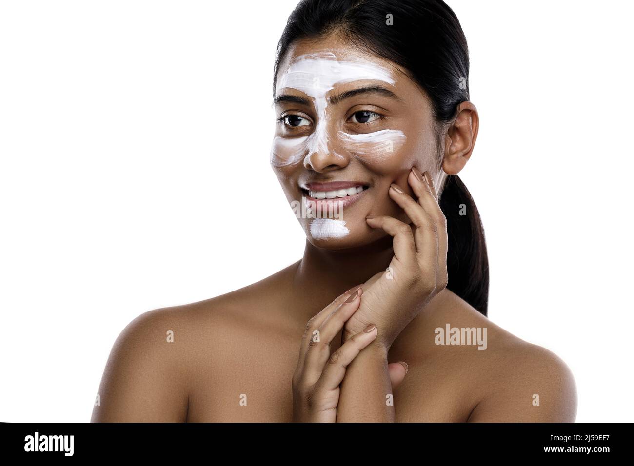 Young indian woman with a cleansing mask applied on her face on white ...