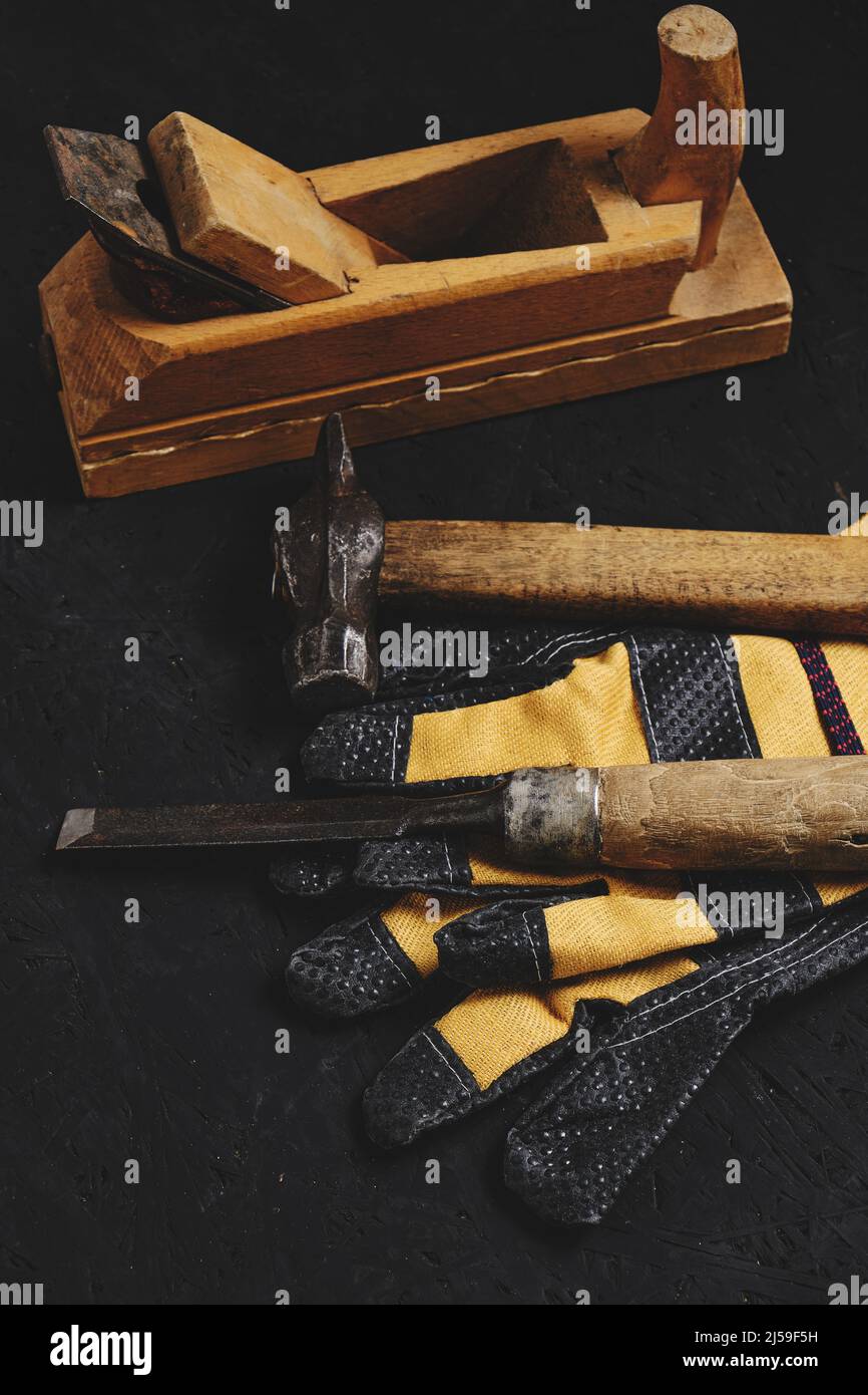 Set of tools for carpenters, hammer, chisel and plane with gloves dark ...