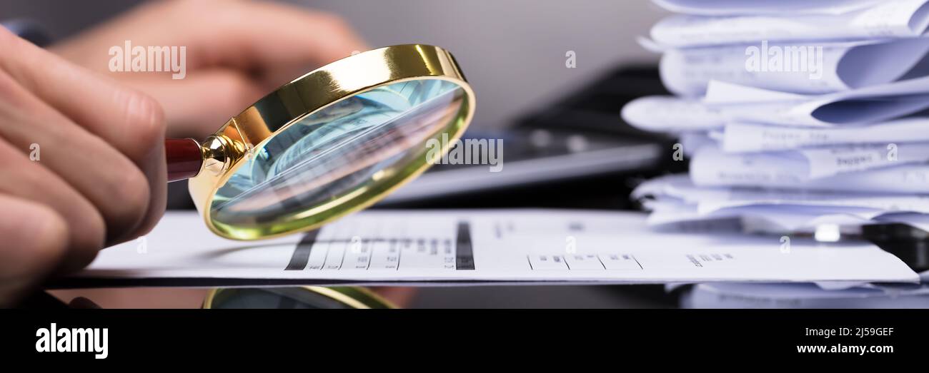 Close-up Of A Businessperson's Hand Looking At Invoice Through ...