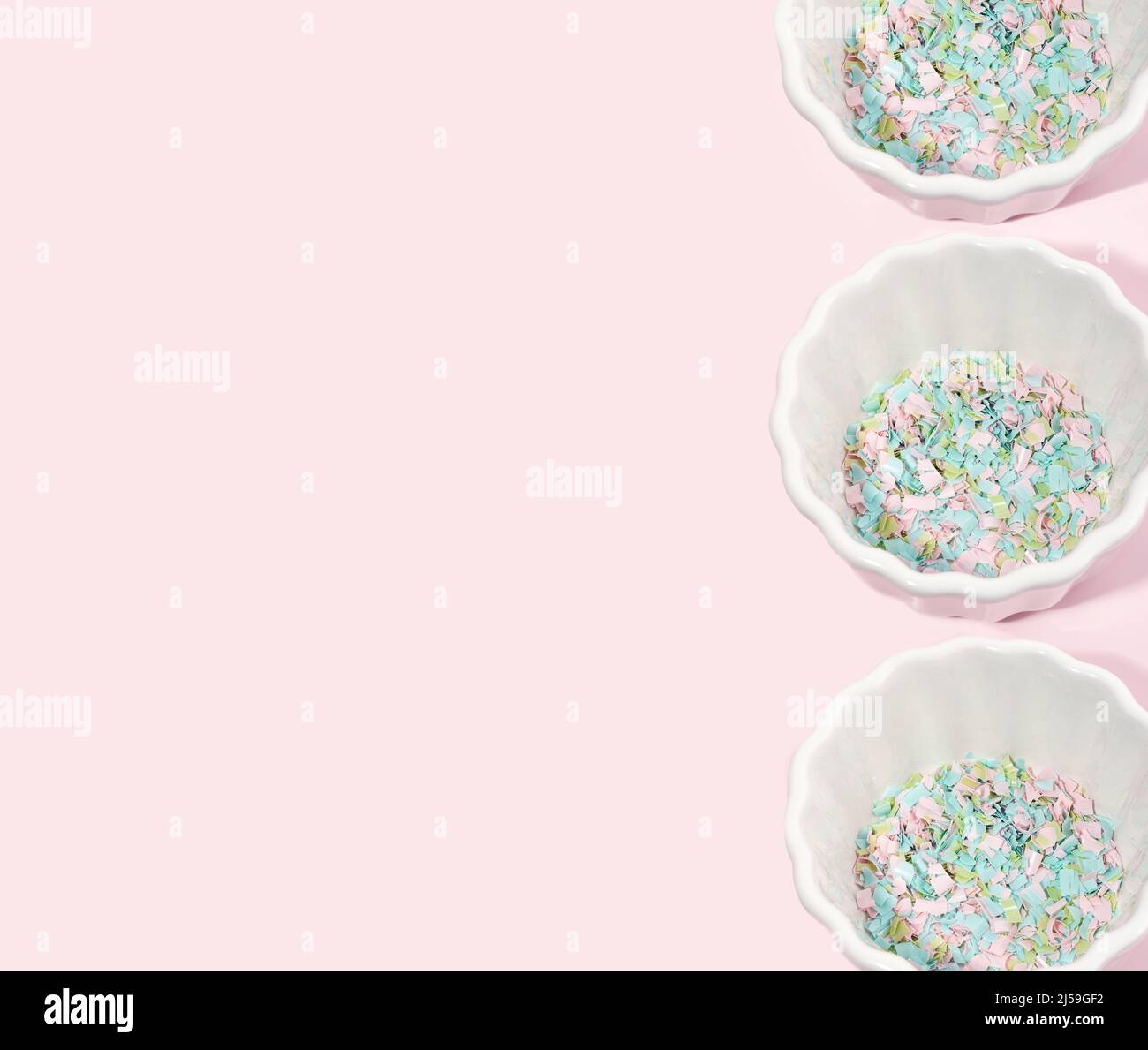 Several bowls full of microplastics on a pink background. Impact of ...