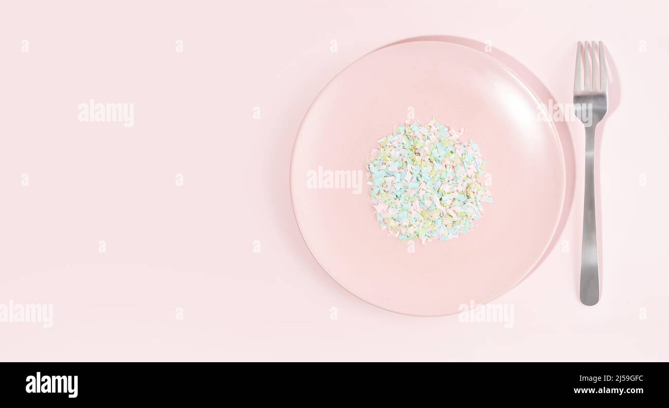 A plate full of microplastics on a pink background. Impact of micro ...