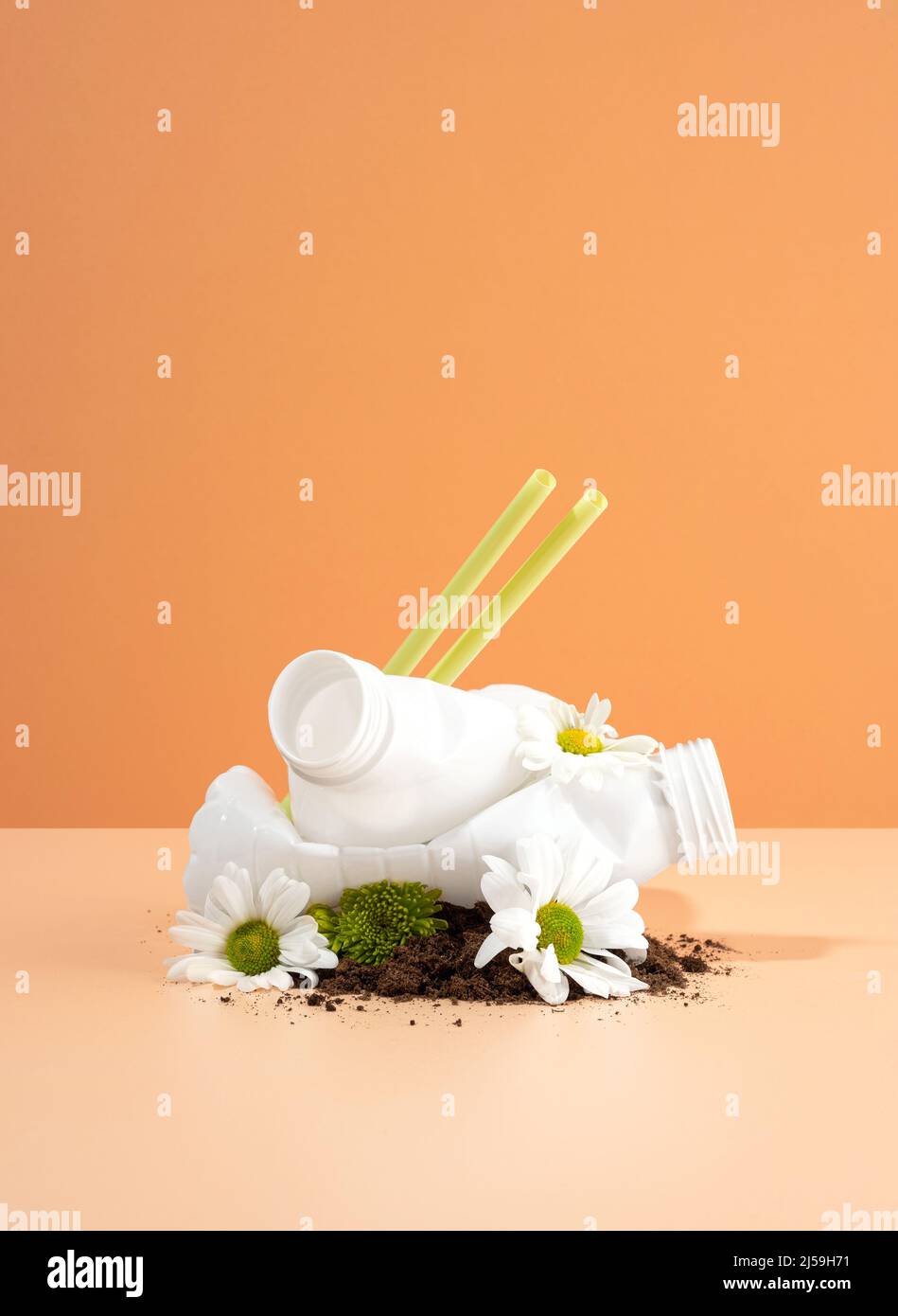 Negative impact on nature. Plastic bottles crush beautiful flowers ...