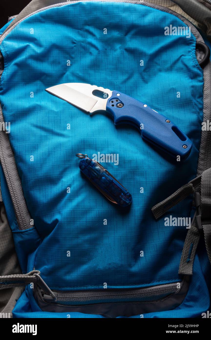 Blue knife and blue backpack. Blue knife on a blue background. Knife ...