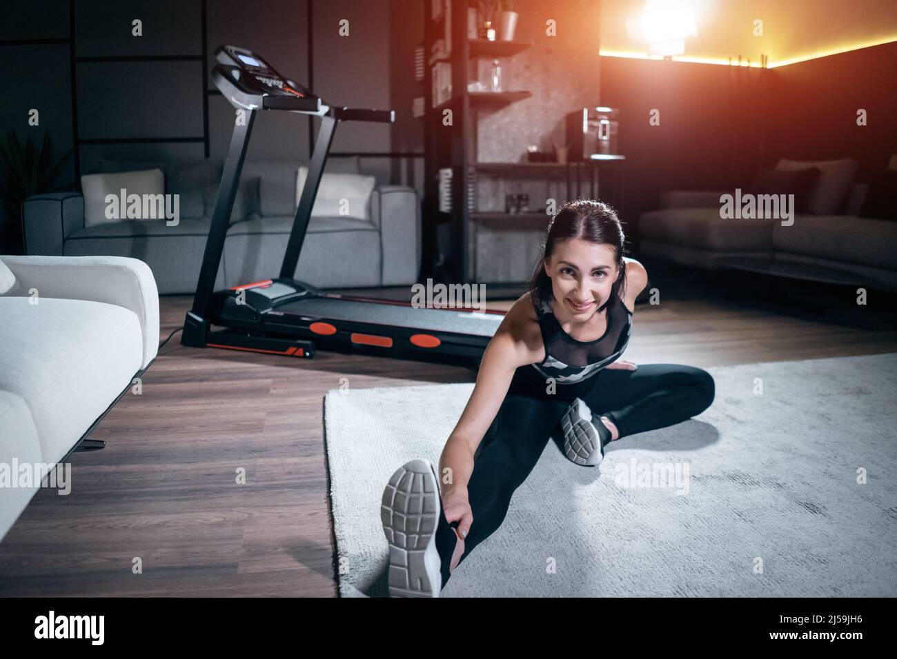 cheerful female stretching and preparing for cardio workout on ...
