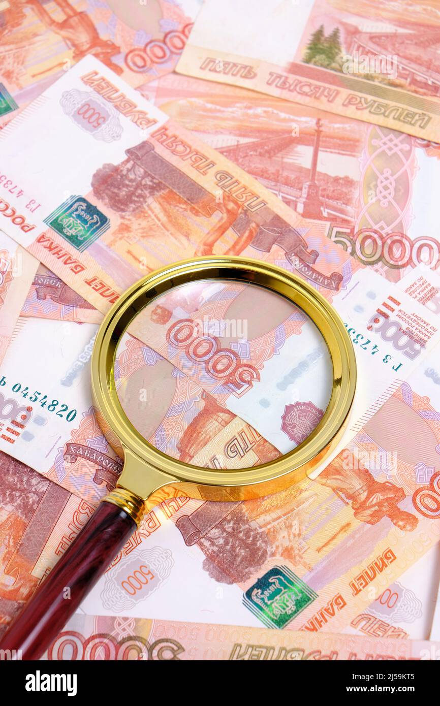 Magnifying magnifier against background Russian rubles with face value ...