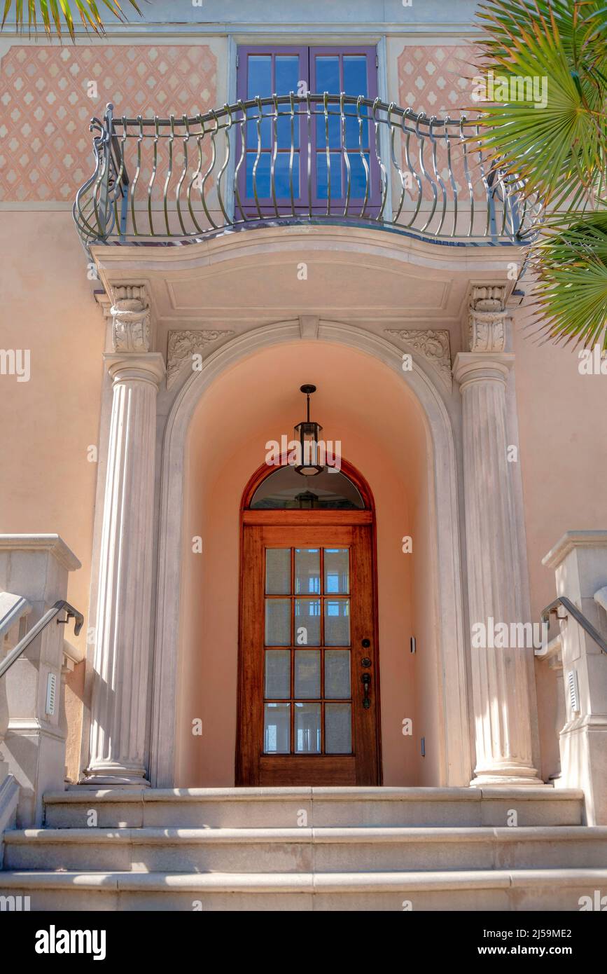 Wooden door with arched transom window below the balcony with double ...
