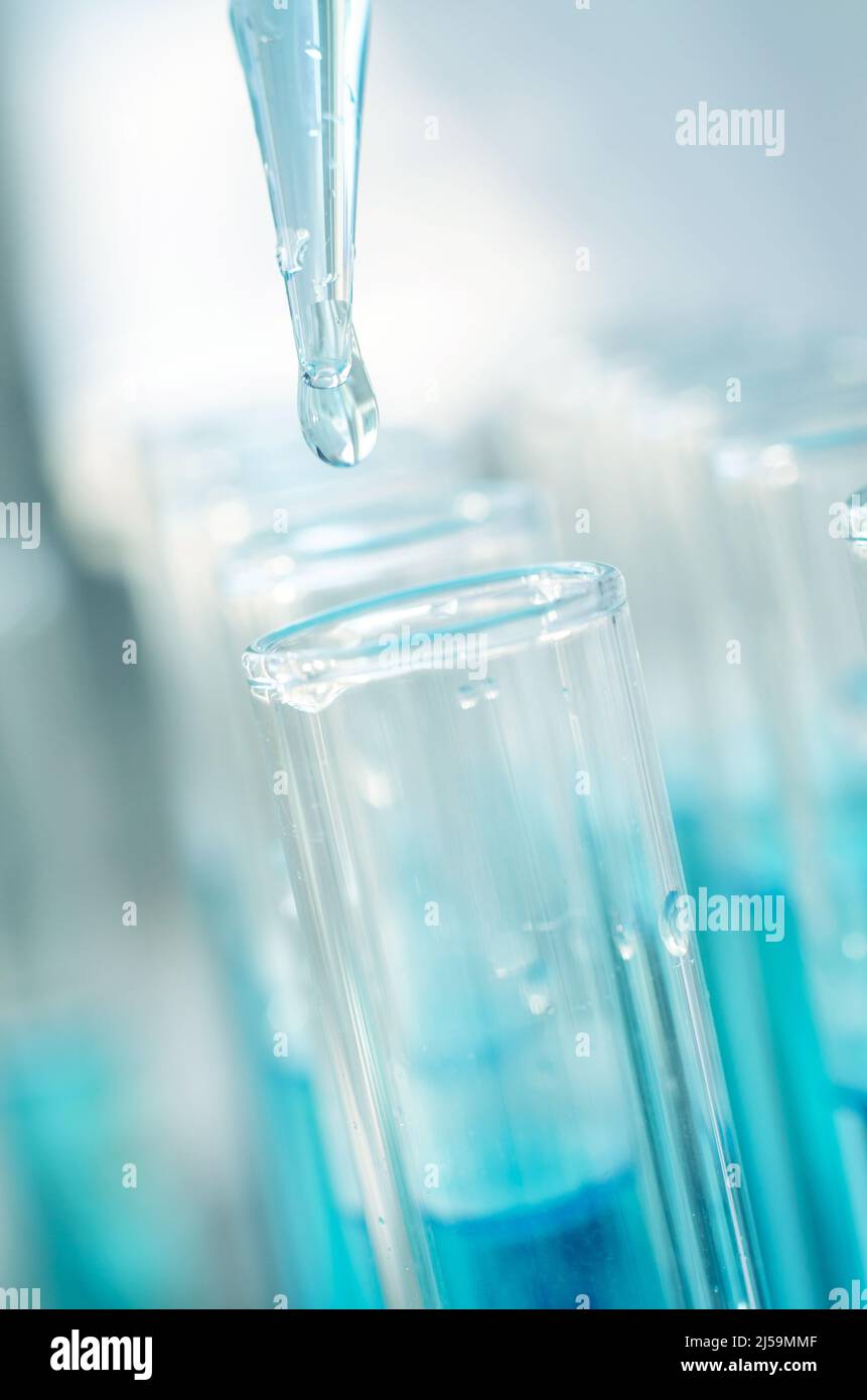 Close-up of a drop from a laboratory pipette dripping into a laboratory ...