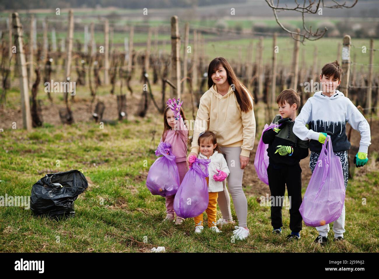Family with trash bag collecting garbage while cleaning in the ...