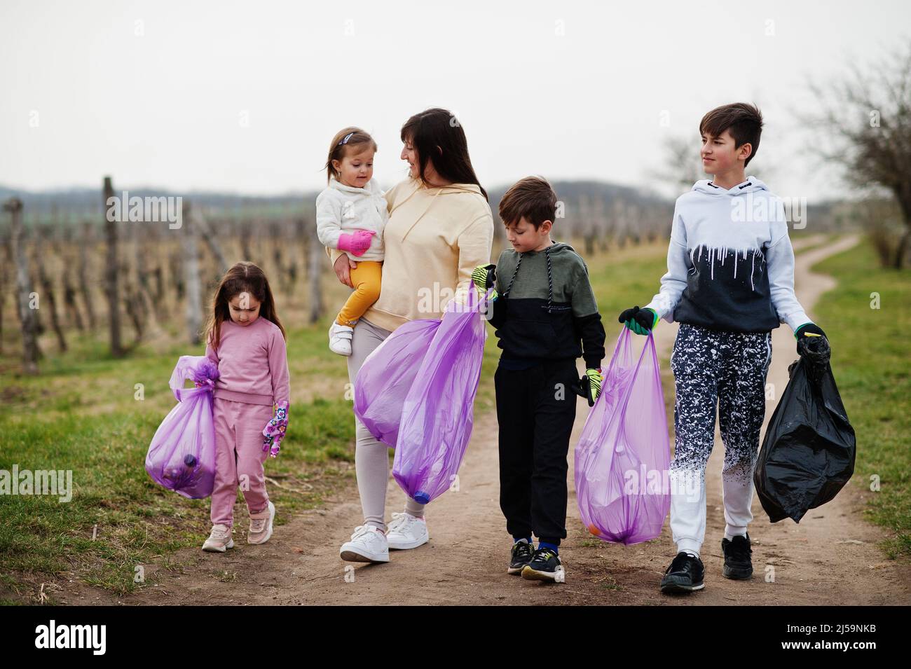 Family with trash bag collecting garbage while cleaning in the ...