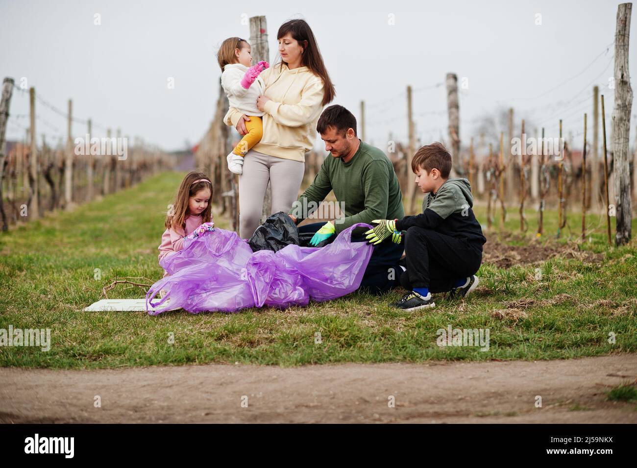 Family with trash bag collecting garbage while cleaning in the ...
