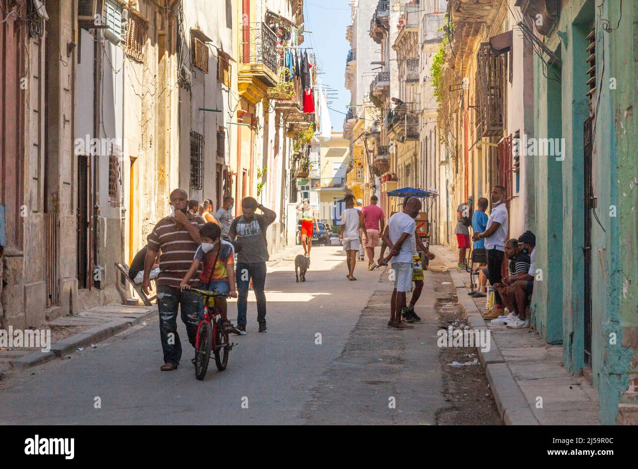 Afternoon lifestyle of real Cuban people in a narrow city street. Some ...