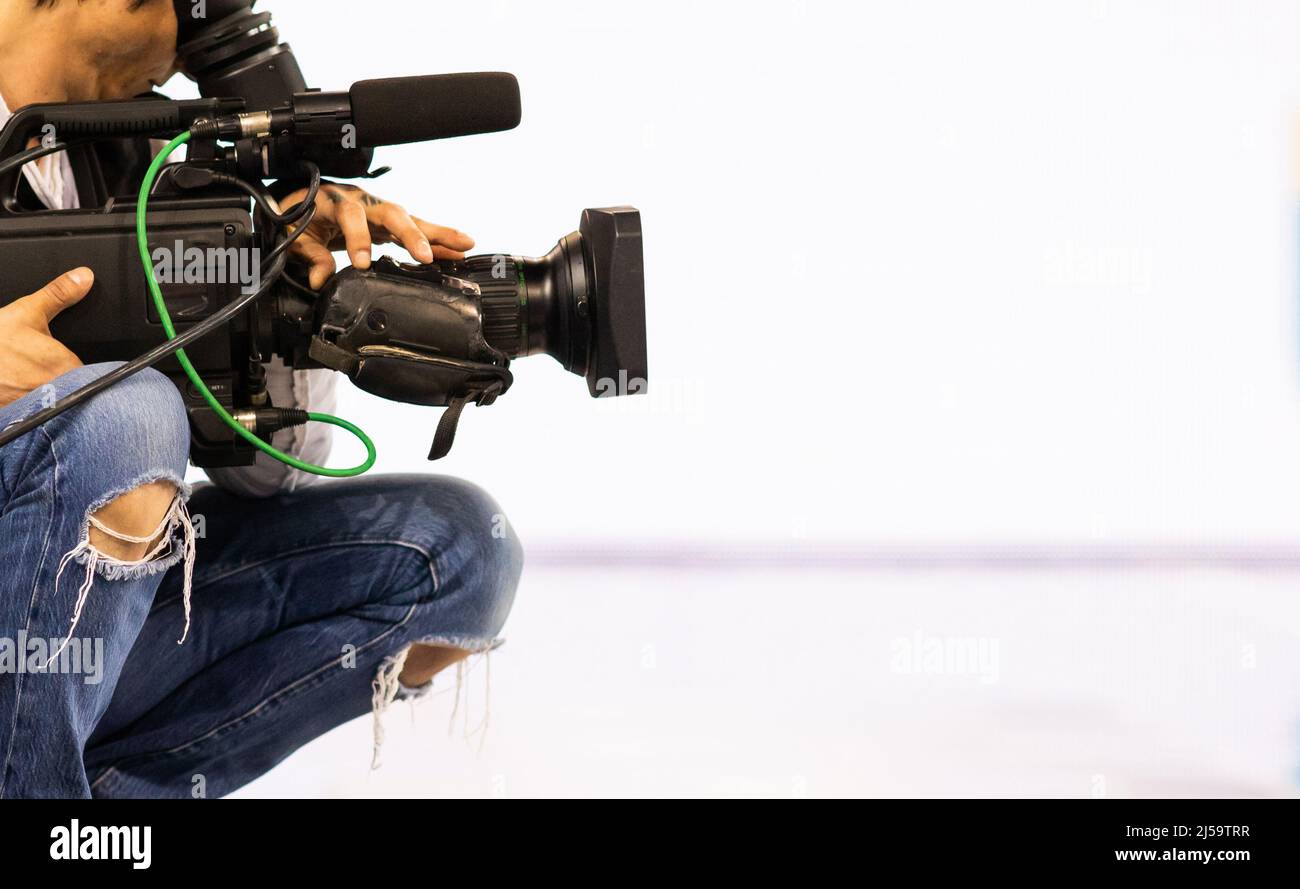 cameraman filming an event focus on camera Stock Photo - Alamy
