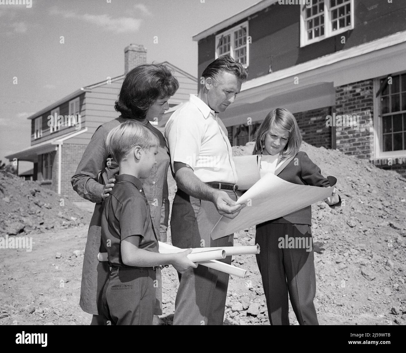 1960s FAMILY OF FOUR DAD MOM DAUGHTER SON STANDING ON HOUSING ...