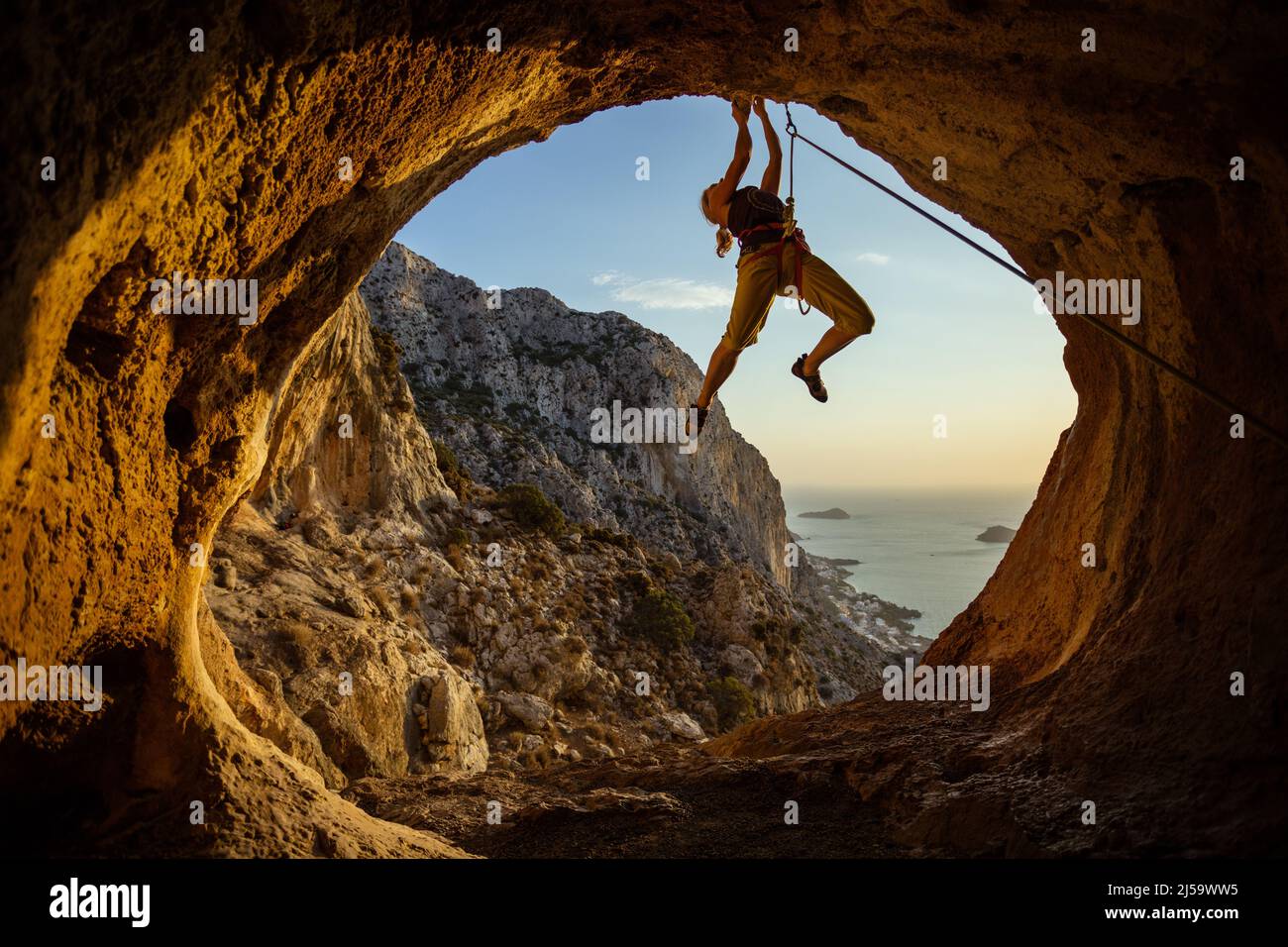 Young woman climbing challenging route in cave Stock Photo - Alamy