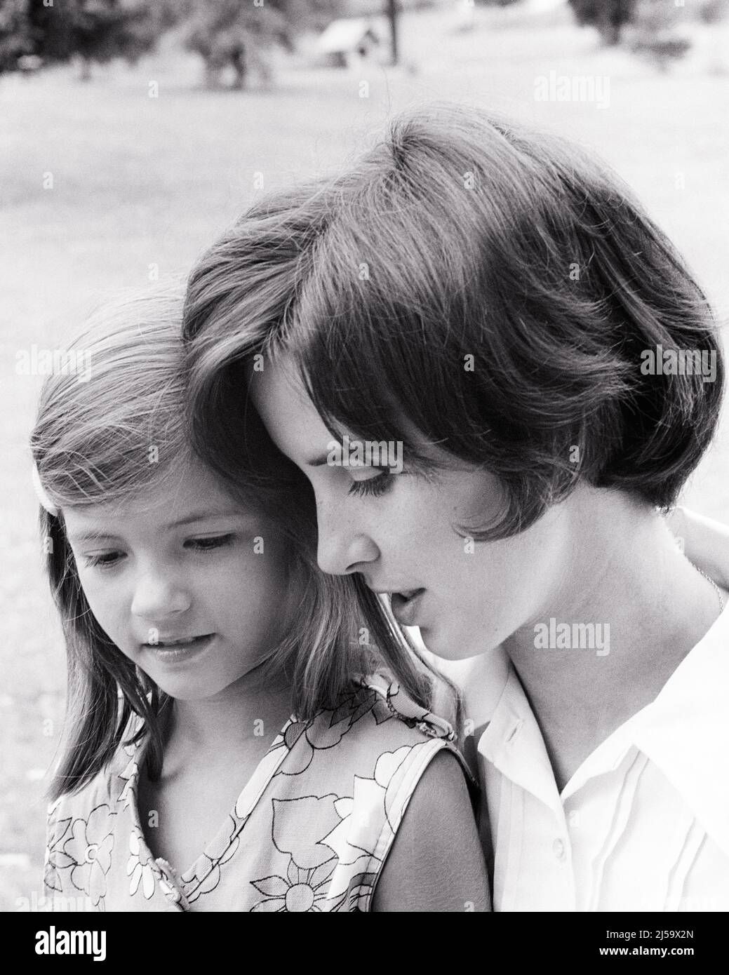 1970s WOMAN MOTHER WITH BRUNETTE HAIR PUTTING HEAD TOGETHER WITH LITTLE ...