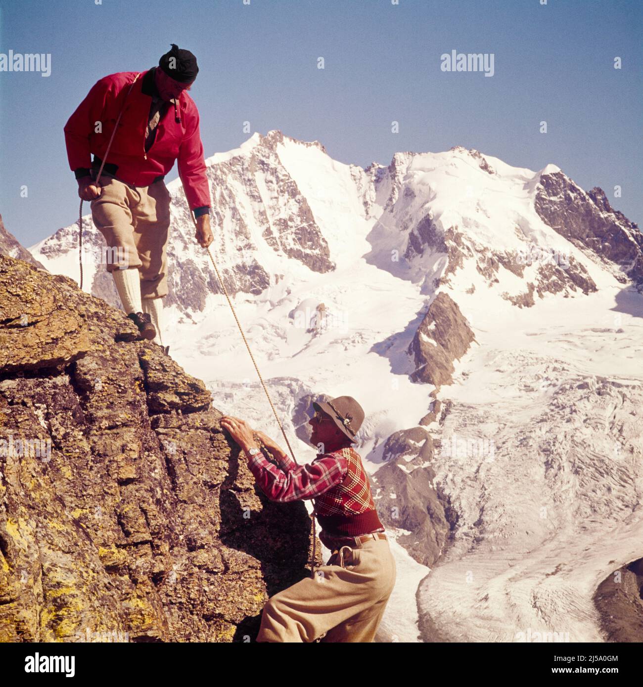 1960s TWO MEN CLIMBING IN SWISS ALPS USING ROPES TO AID IN ASCENT OF ...
