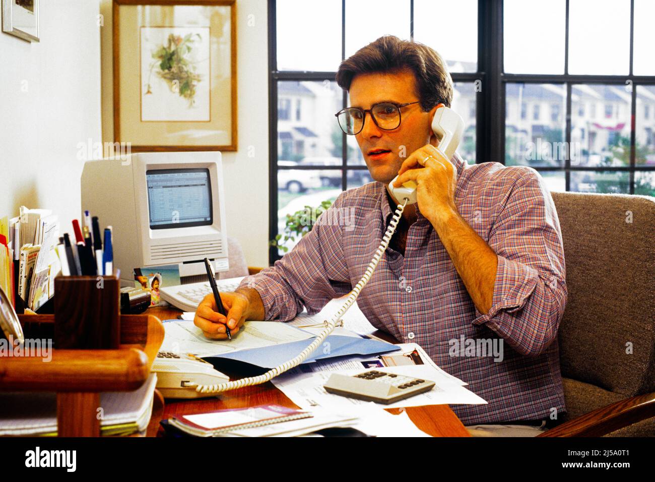 1990s SALESMAN TALKING ON TELEPHONE WITH A DESKTOP MACINTOSH CLASSIC ...