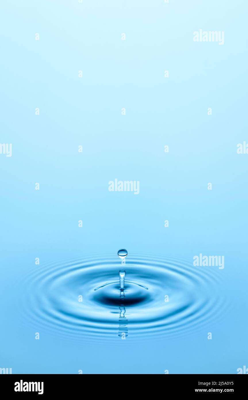 Drop falling on the water with space above Stock Photo - Alamy