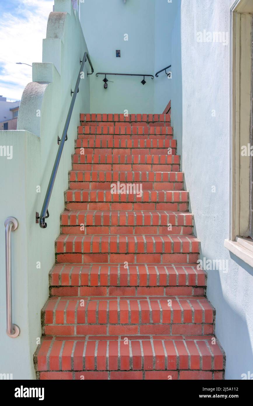 Red bricks outdoor staircase with wall-mounted metal handrail at San ...