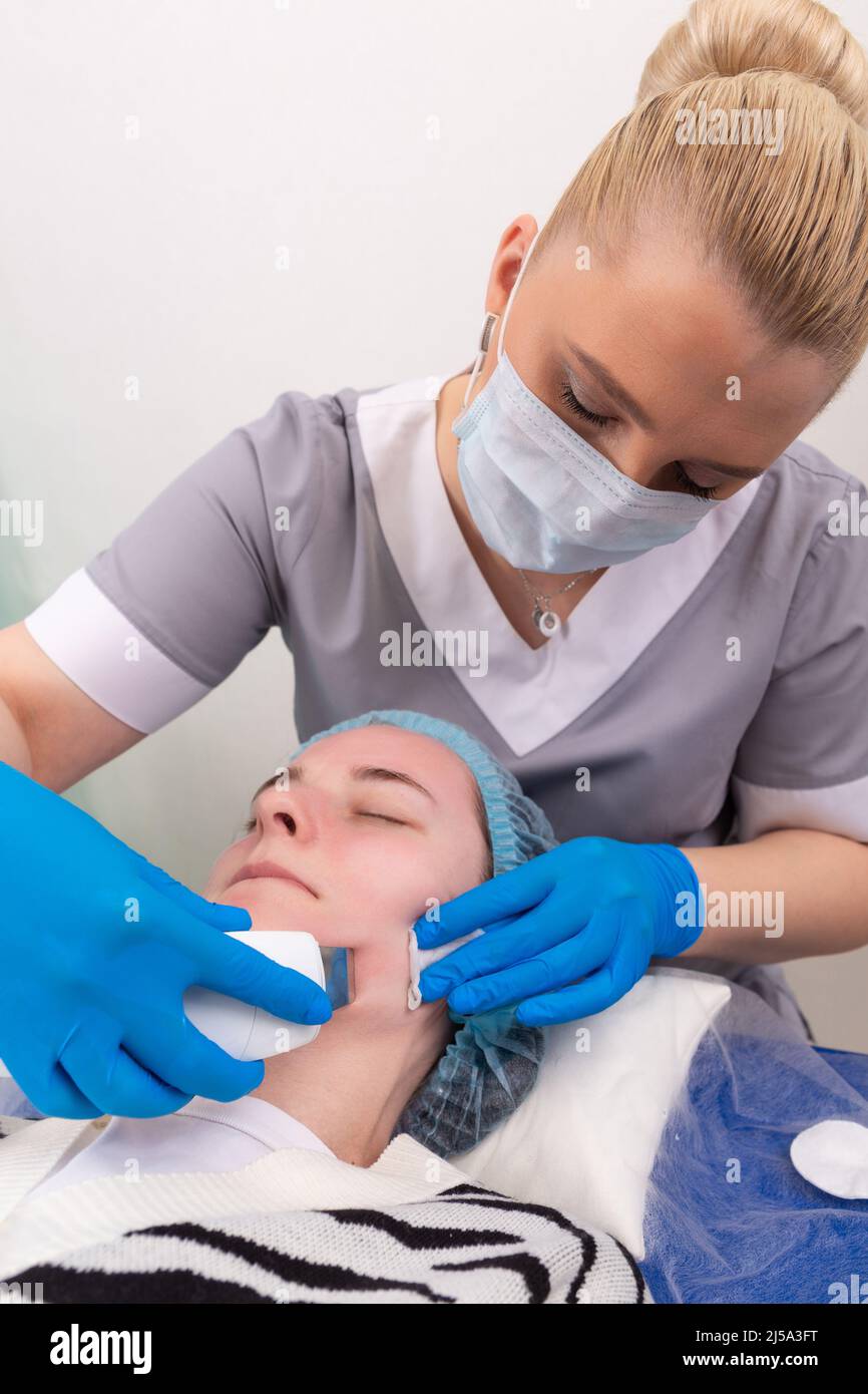 Ultrasound facial peeling. Young woman getting ultrasonic peel skin ...