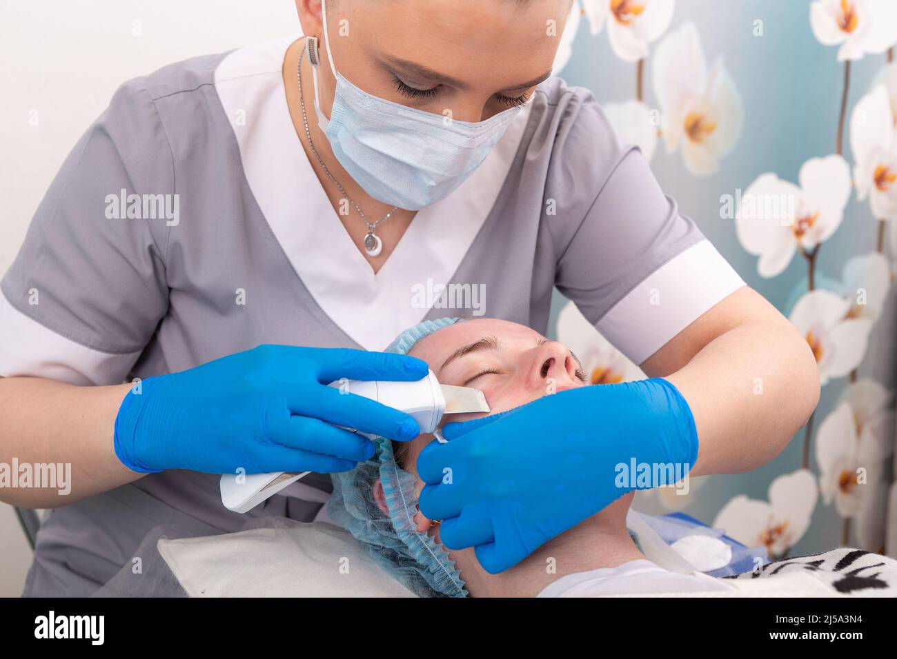 Ultrasound facial peeling. Young woman getting ultrasonic peel skin ...
