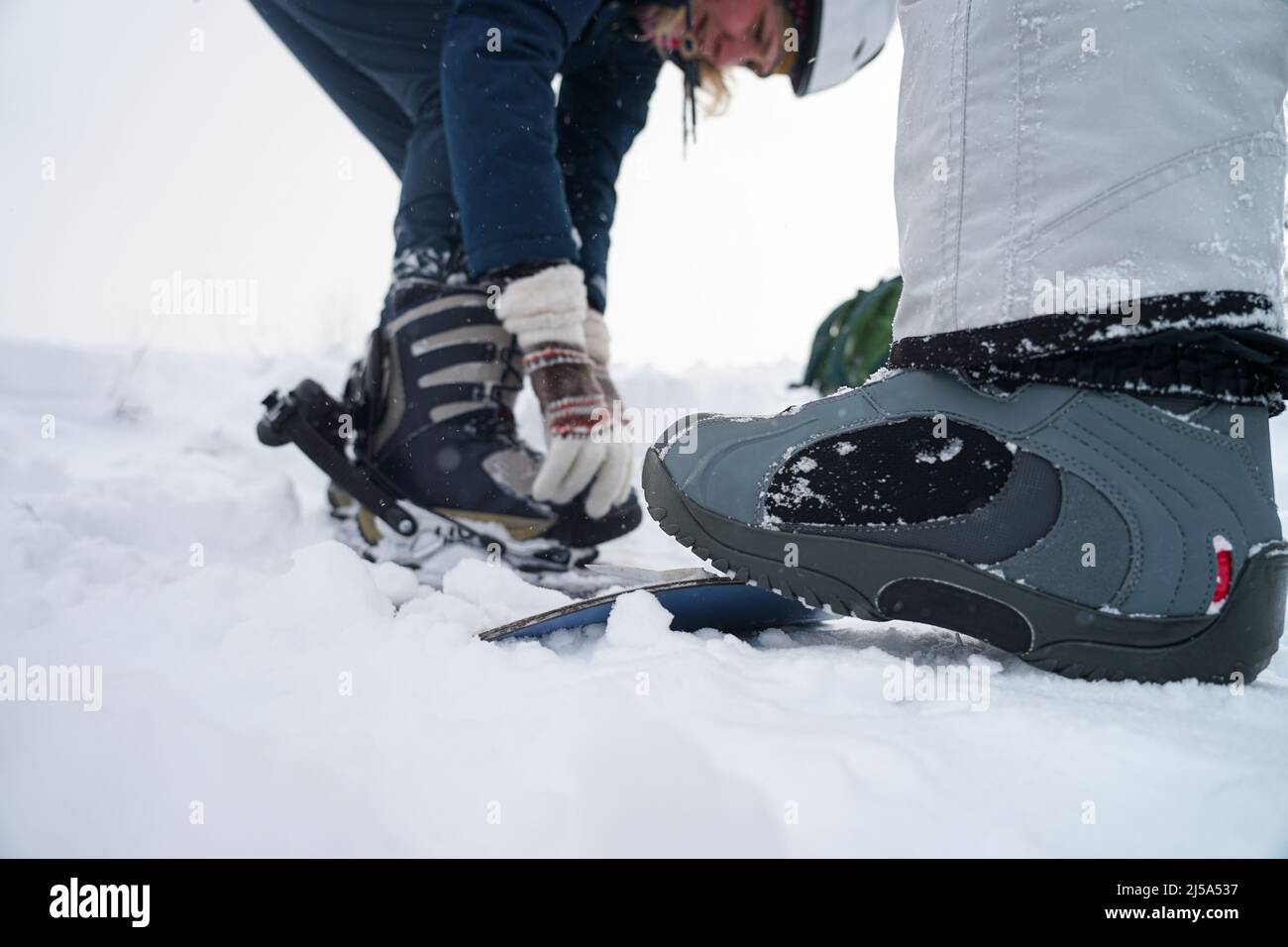 Foot in a boot holds a snowboard on a slope Stock Photo - Alamy