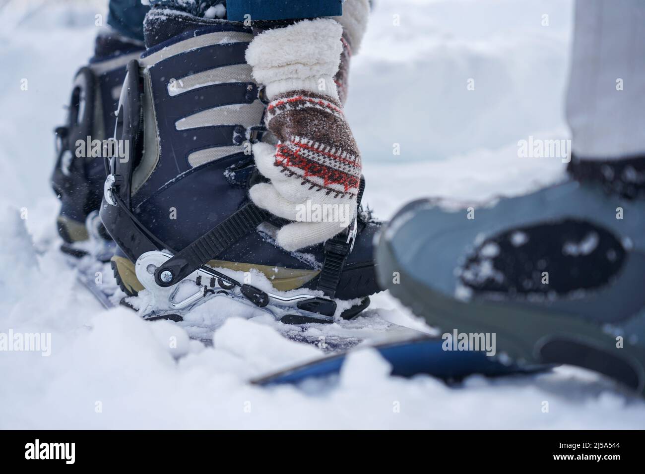 Girl fastening snowboard binding Stock Photo - Alamy