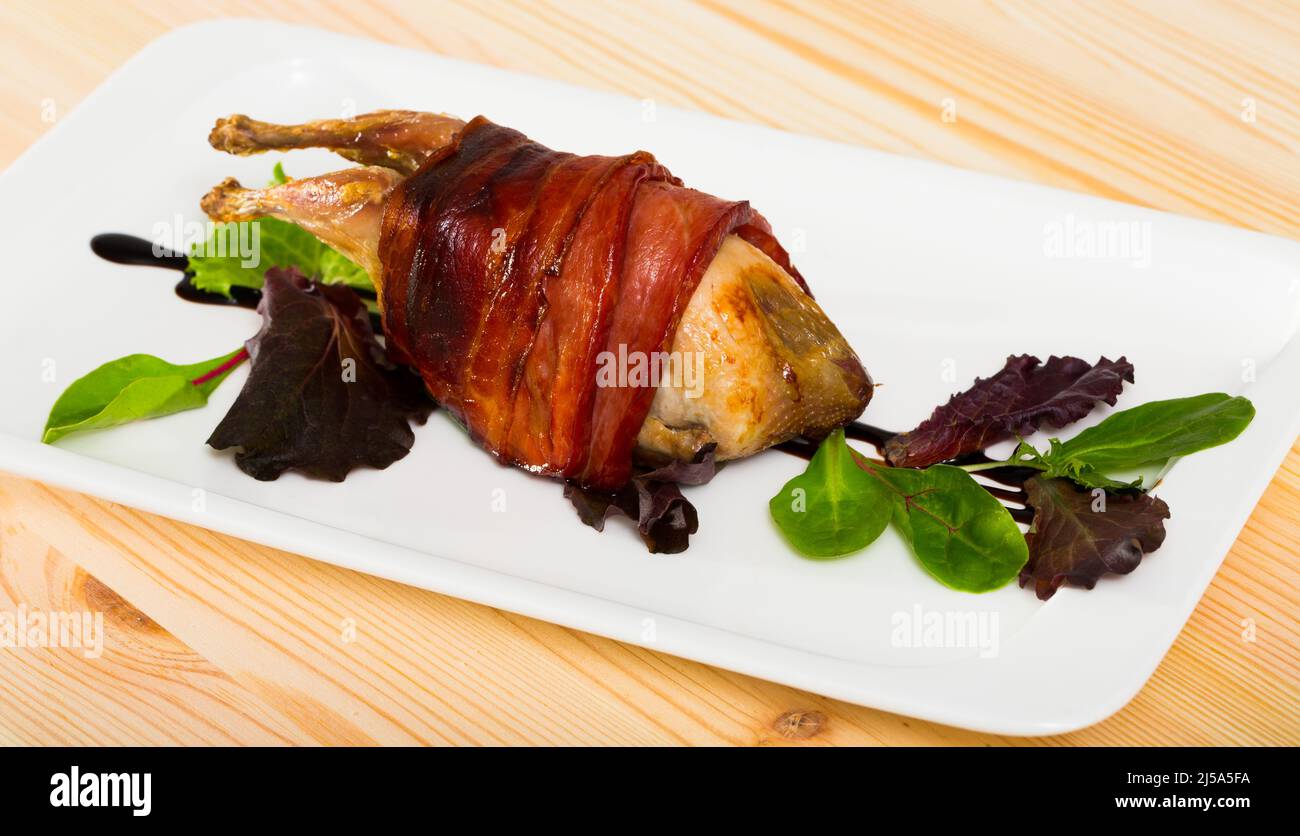 Baked in bacon small quail with balsamic sauce, served with lettuce ...