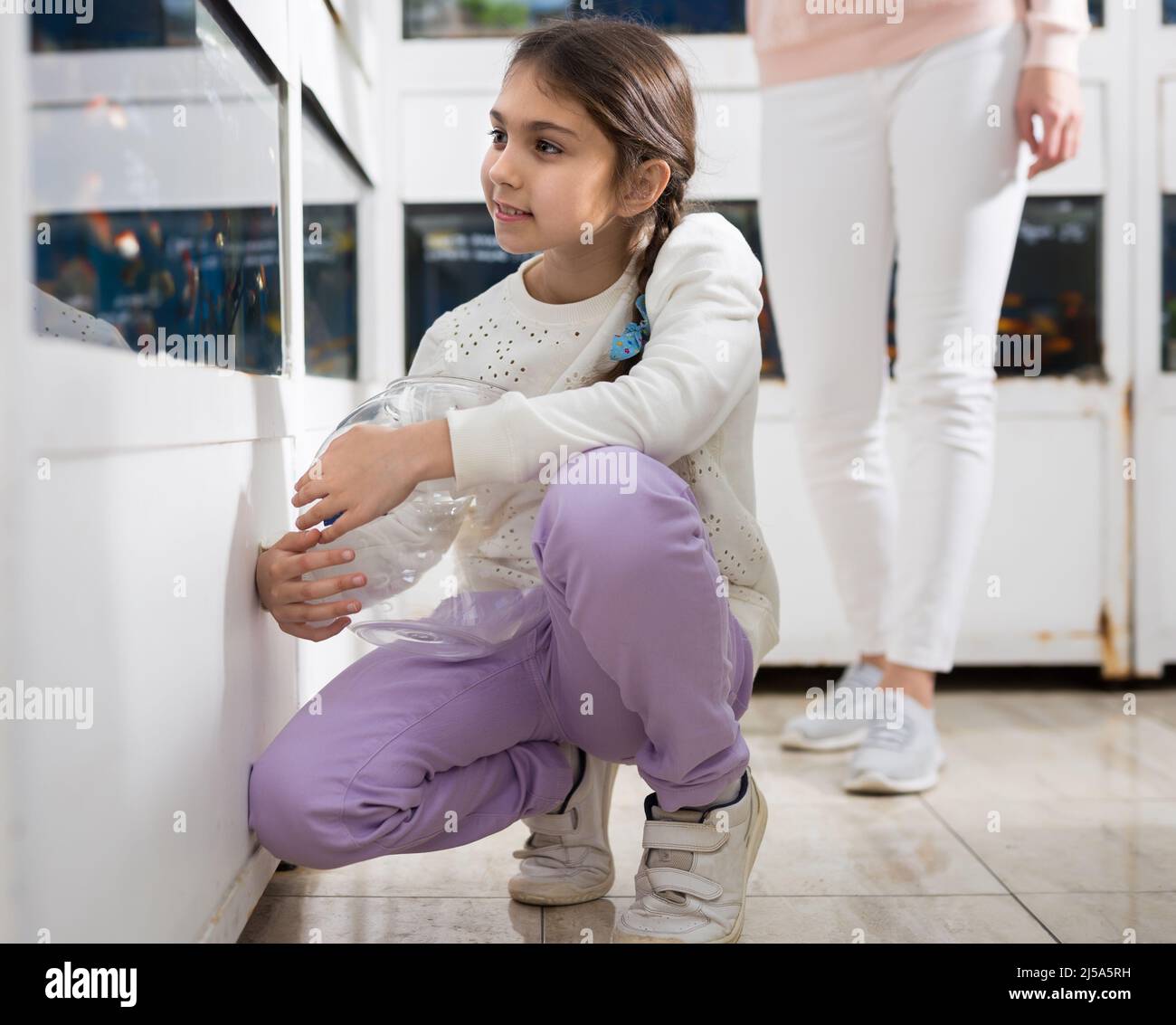Portrait of kid girl looking for new fish for small home aquarium Stock ...