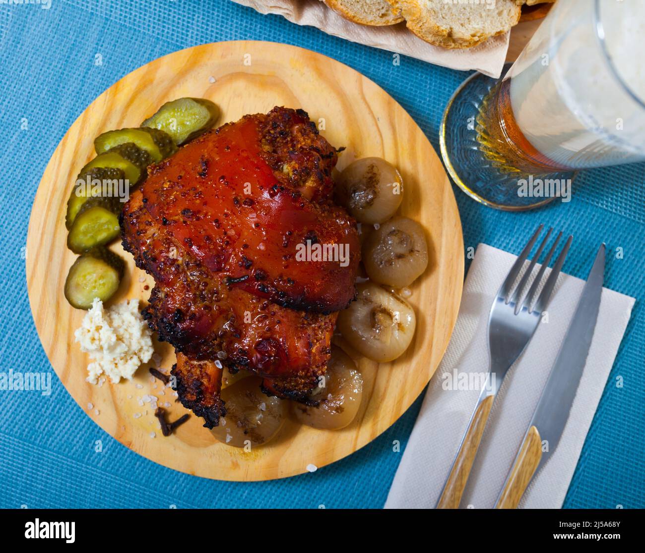 Oven baked pork knuckle with boiled onions and pickled cucumbers Stock ...