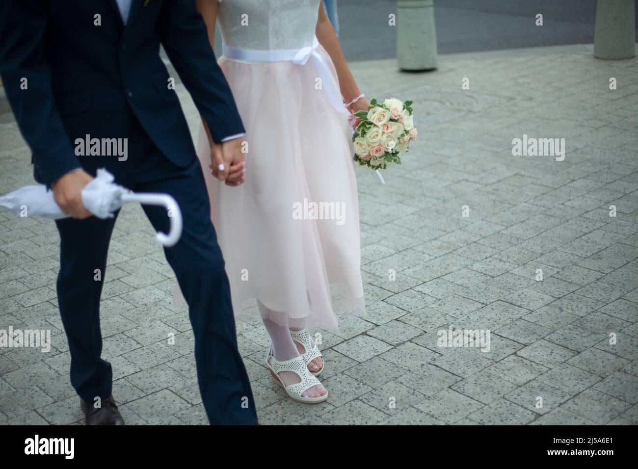 Bride and groom hold hands. Girl in white dress. Details of celebration ...
