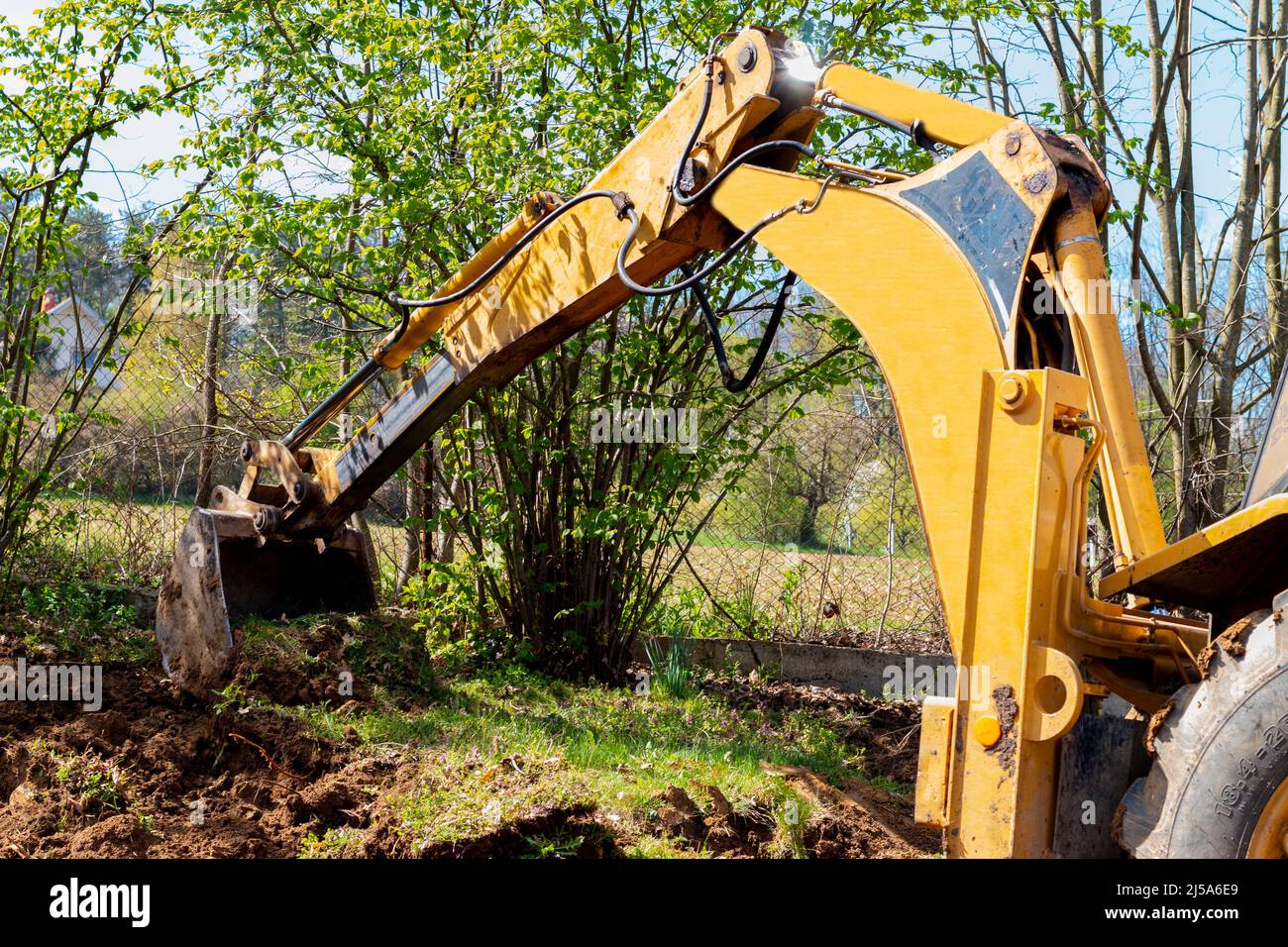 Bucket excavator at work in the countryside in a private yard. Digging ...