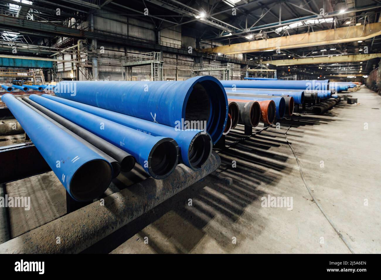 New cast iron pipes for pipeline construction in warehouse Stock Photo ...