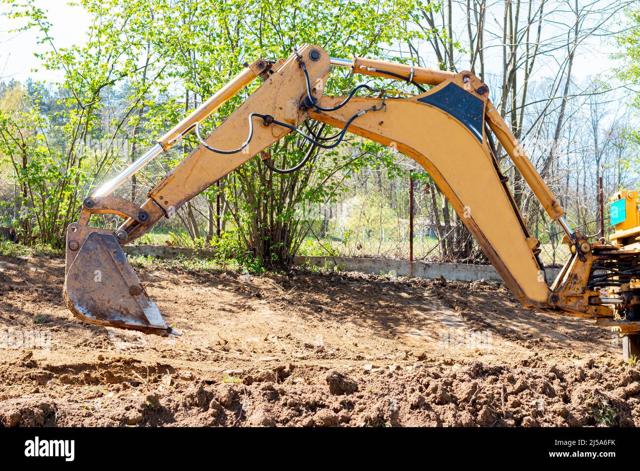 Bucket excavator at work in the countryside in a private yard. Digging ...