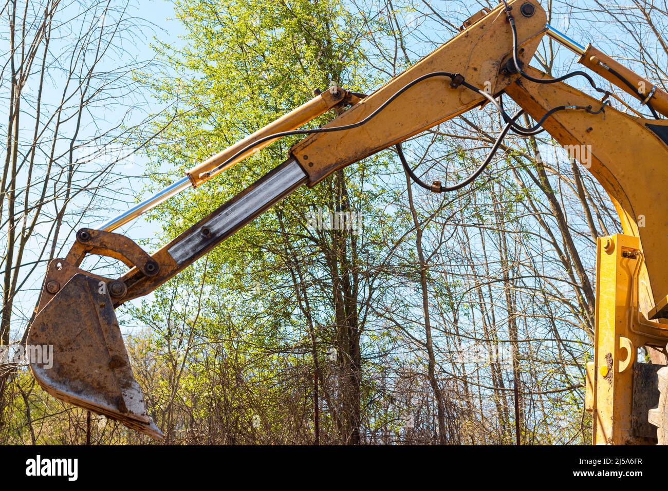 Bucket excavator at work in the countryside in a private yard. Digging ...