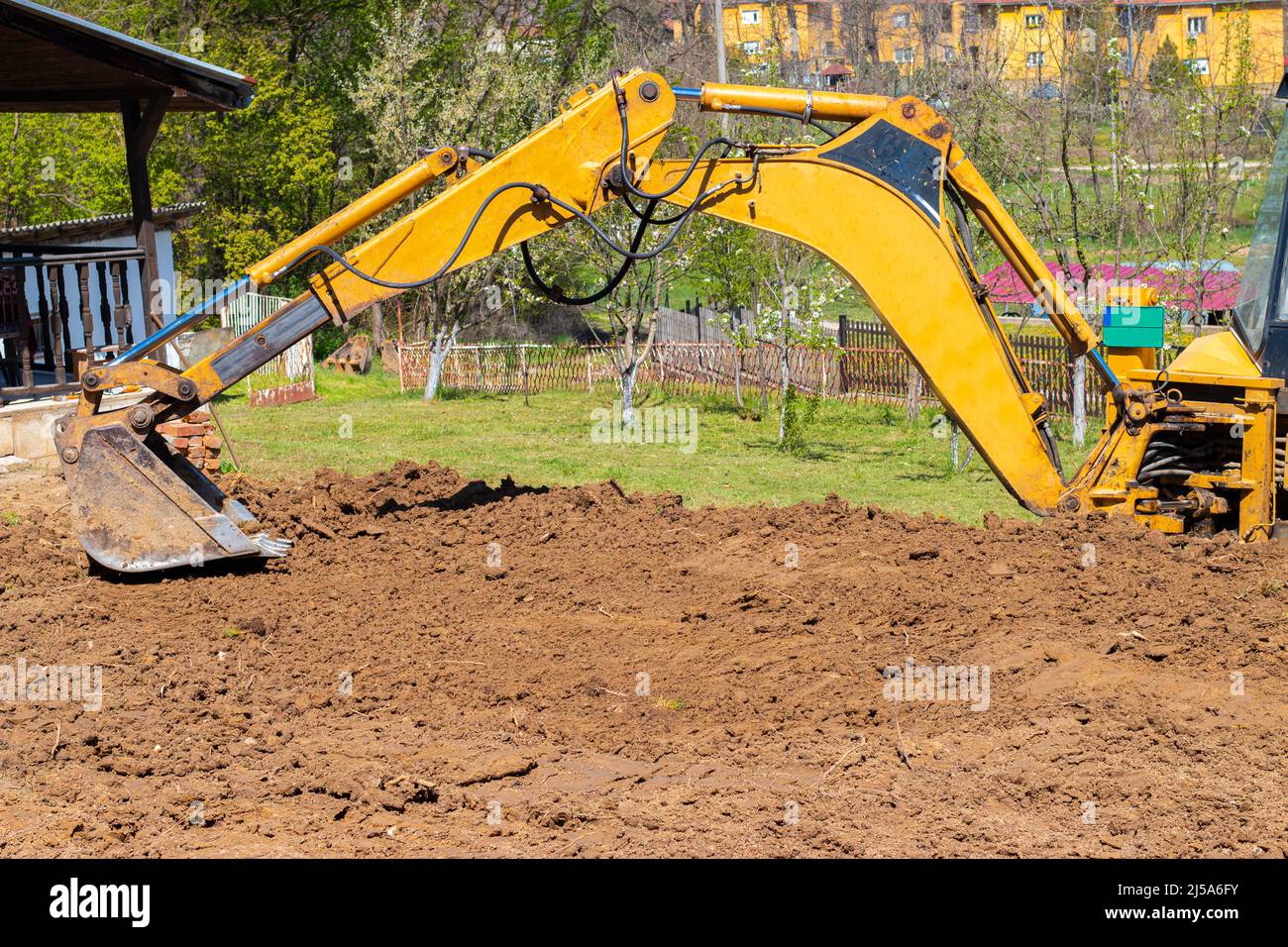 Bucket excavator at work in the countryside in a private yard. Digging ...