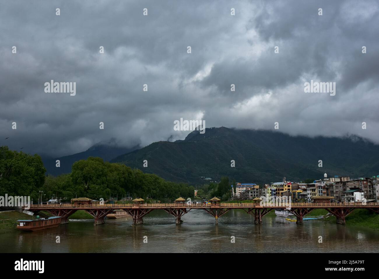 Residents walk through a wooden foot-bridge on a cloudy day. The ...