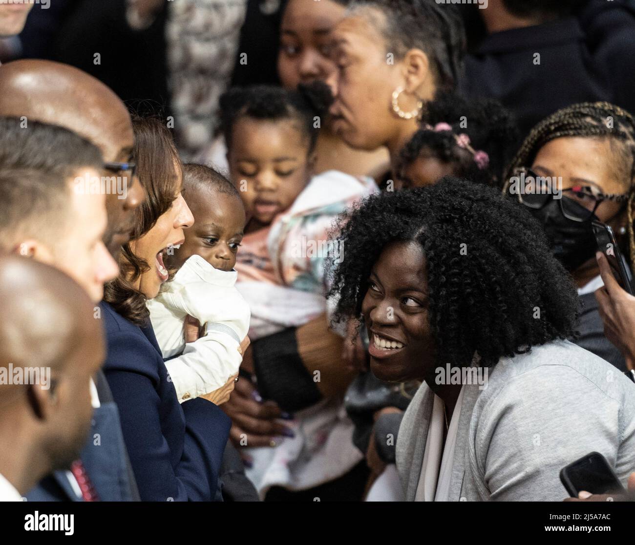 Vice President Kamala Harris holds a baby and interacts with the mother ...