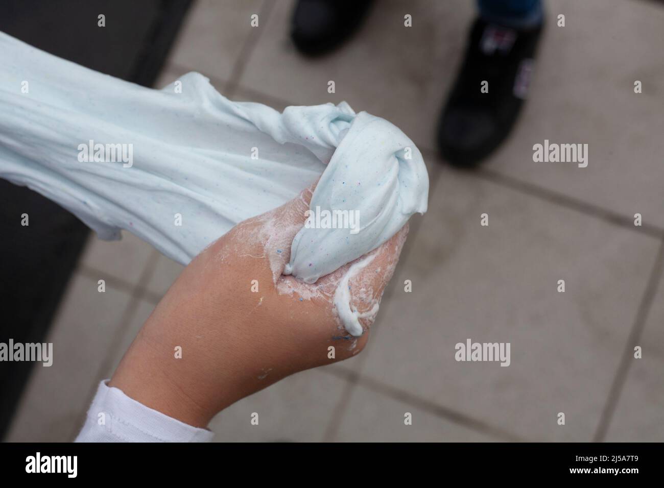 The child wrinkles slime in his hands. Sticky substance. Products made ...