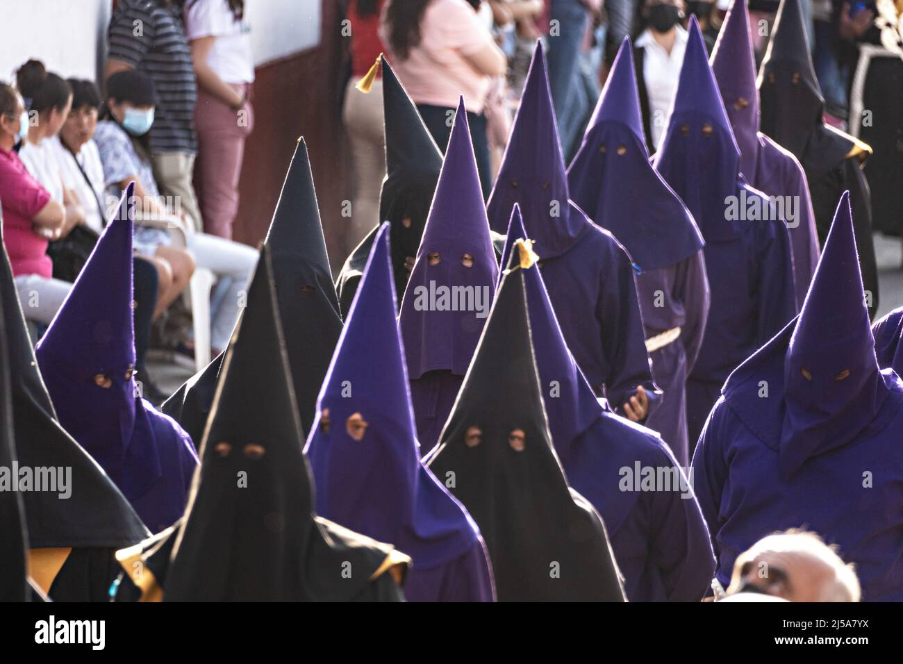 Roman Catholic hooded penitents wearing traditional capirotes, hold a ...