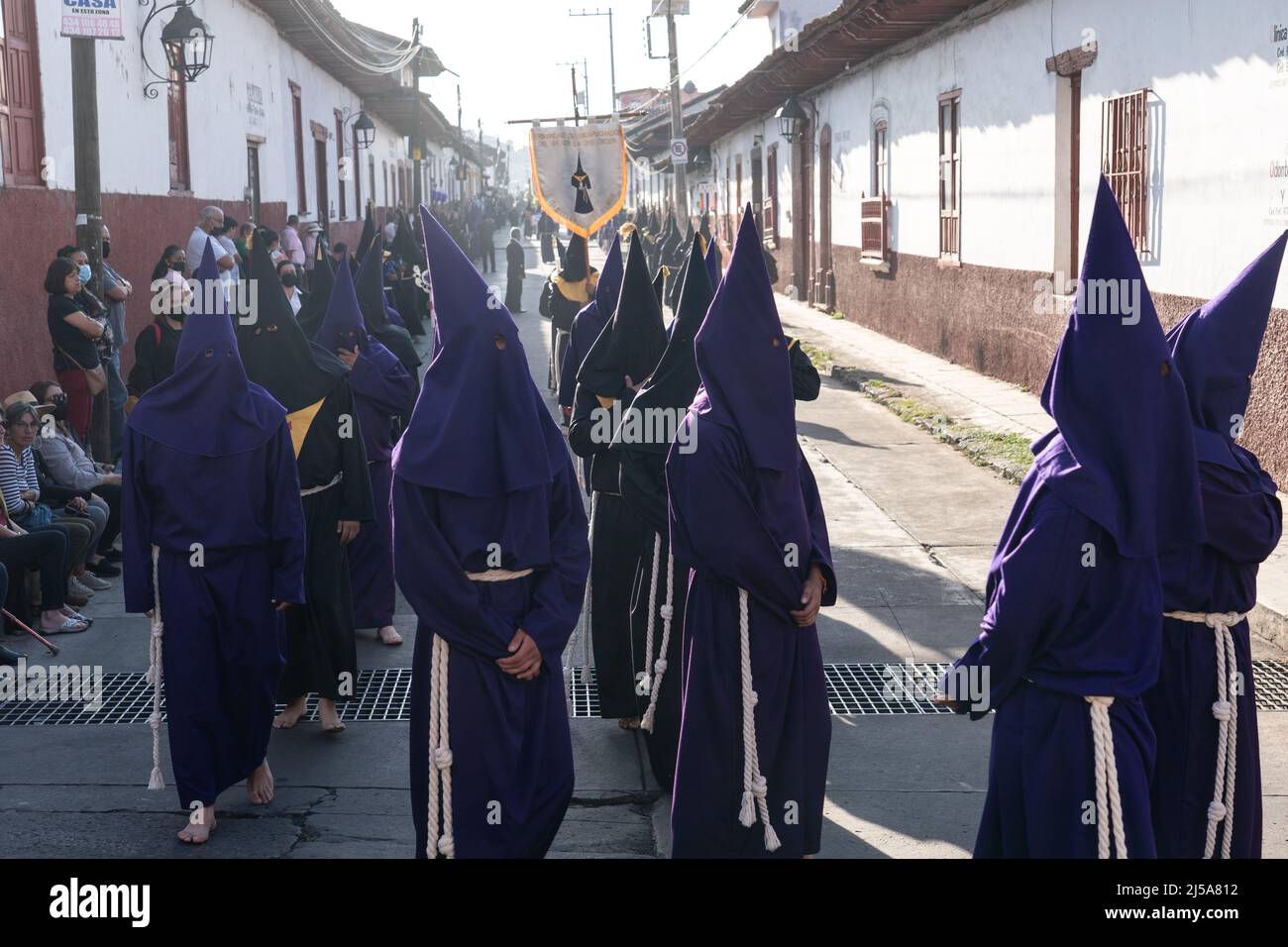 Roman Catholic hooded penitents wearing traditional capirotes, hold a ...