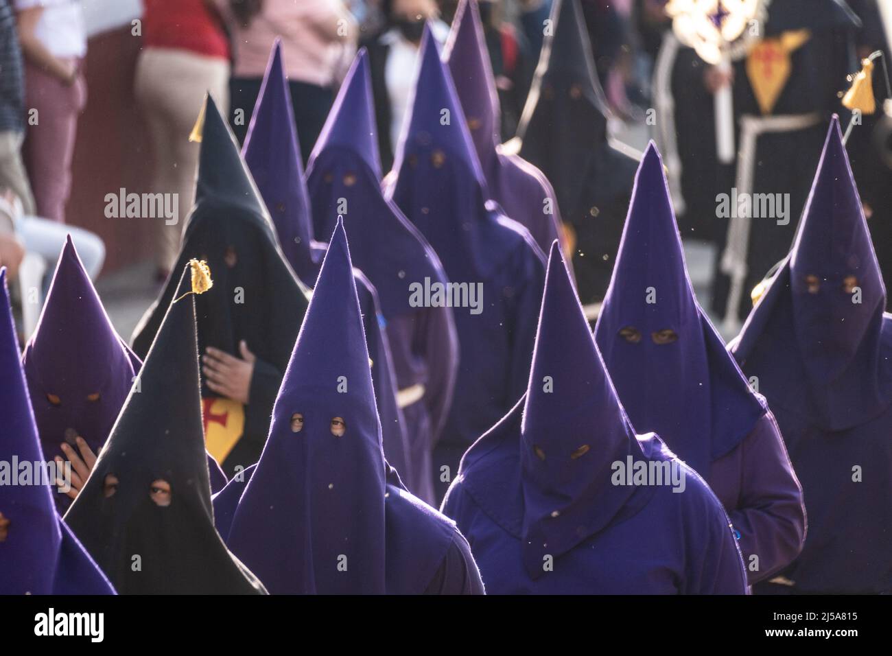 Roman Catholic hooded penitents wearing traditional capirotes, hold a ...