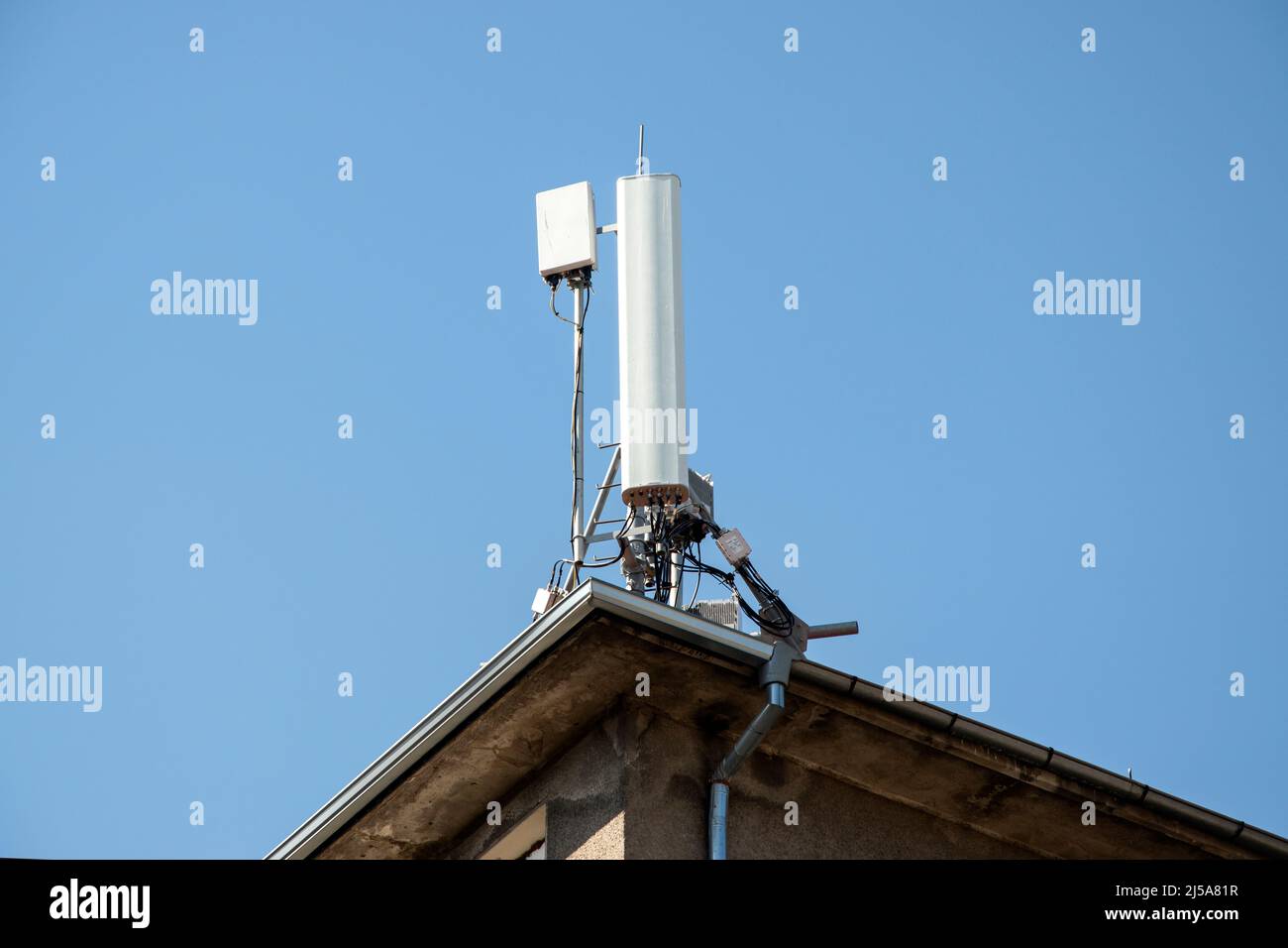 GSM mobile phone antenna tower on house roof Stock Photo - Alamy
