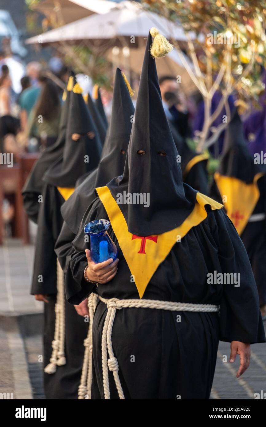 Roman Catholic hooded penitents wearing traditional capirotes, hold a ...
