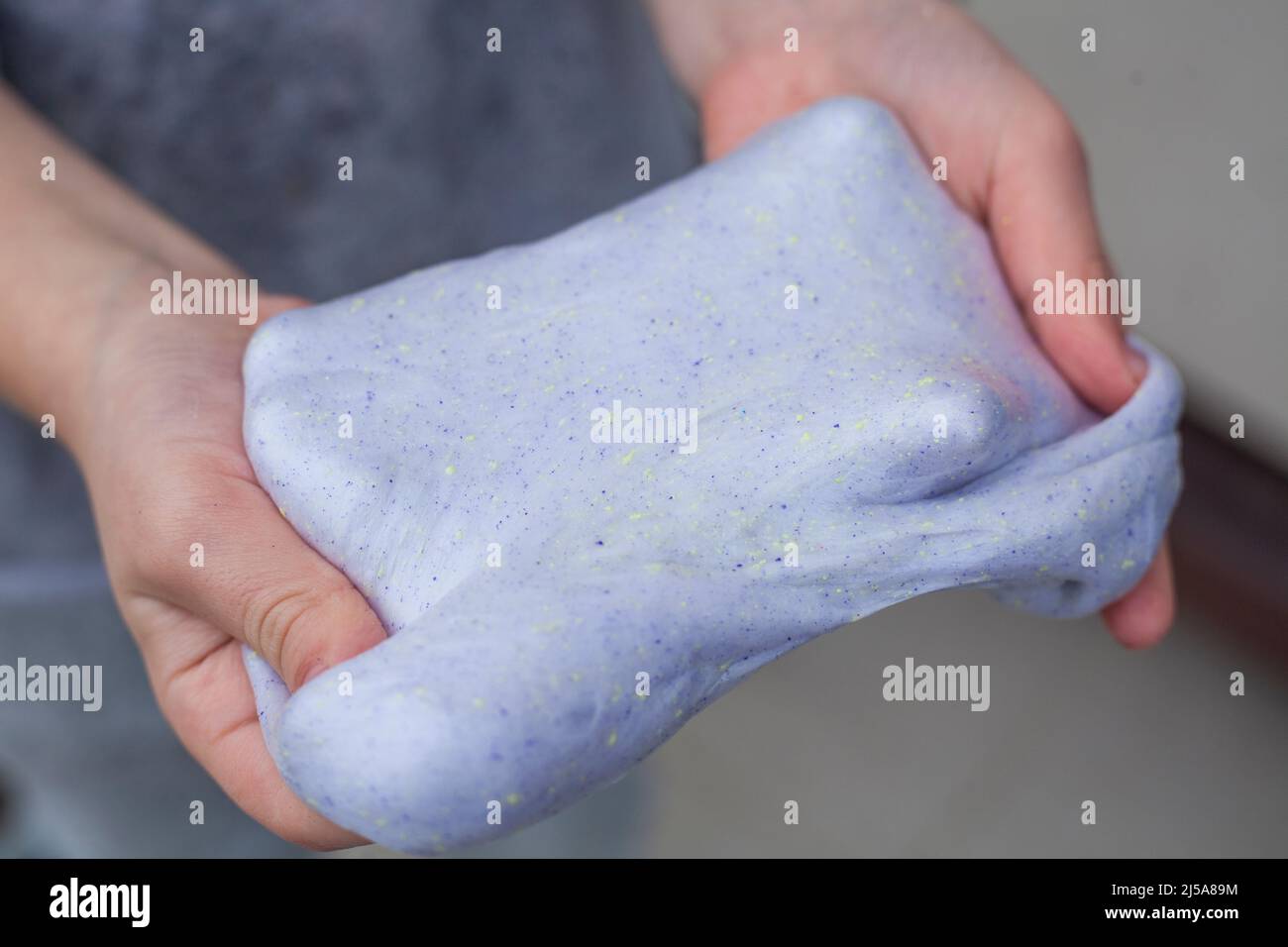 The child wrinkles slime in his hands. Sticky substance. Products made ...