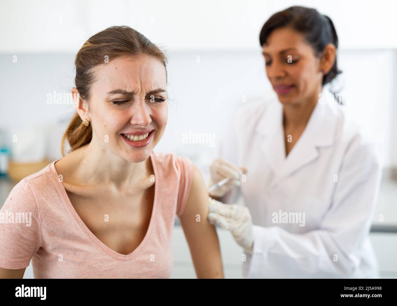 Woman client of medical clinic afraid of syringe Stock Photo - Alamy